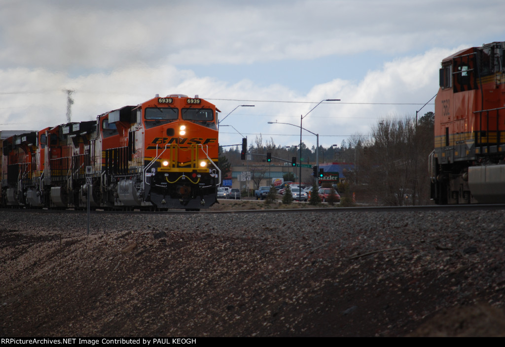 BNSF 6939 Heads east as she approaches BNSF 7562 stopped on Main Track 1 due to the Maintenance ...